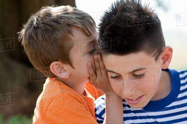 Boy whispering to firiend - Royalty-free Stock Photo | Dissolve