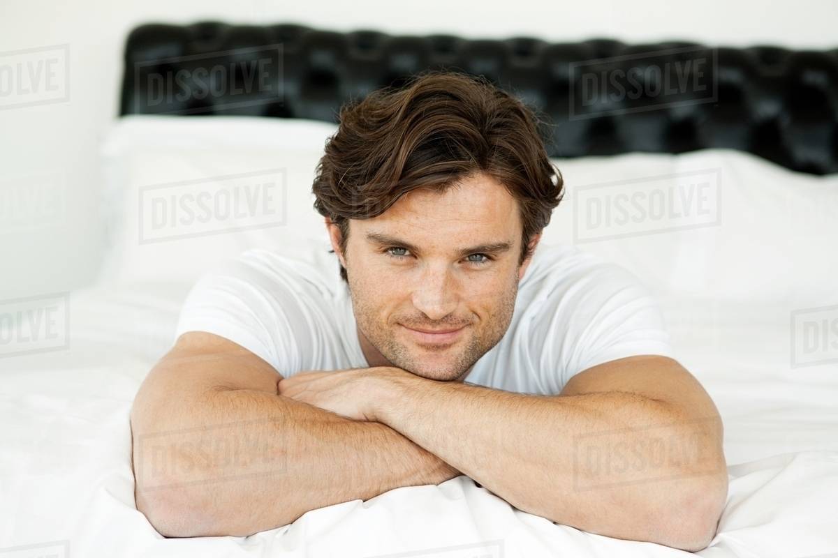 Man lying on bed, portrait - Royalty-free Stock Photo | Dissolve