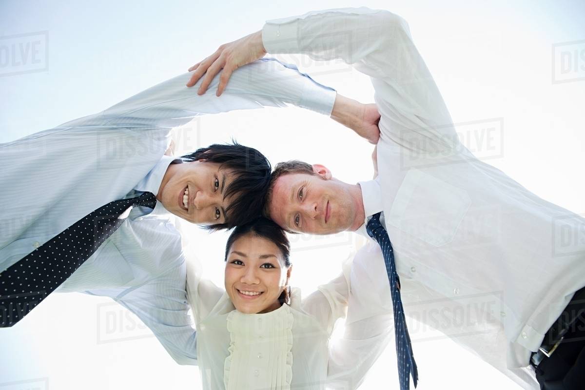 Multi ethnic businesspeople in huddle - Stock Photo - Dissolve