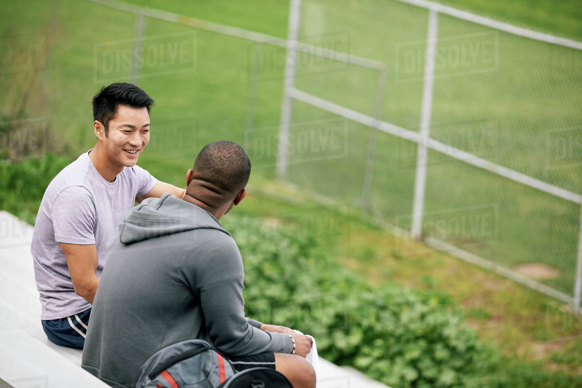 Two friends talking on bench - Royalty-free Stock Photo | Dissolve