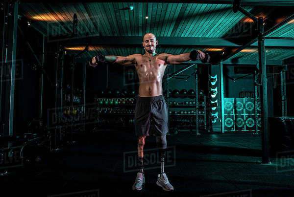 Shirtless young man with prosthetic legs working out in gym - Stock ...