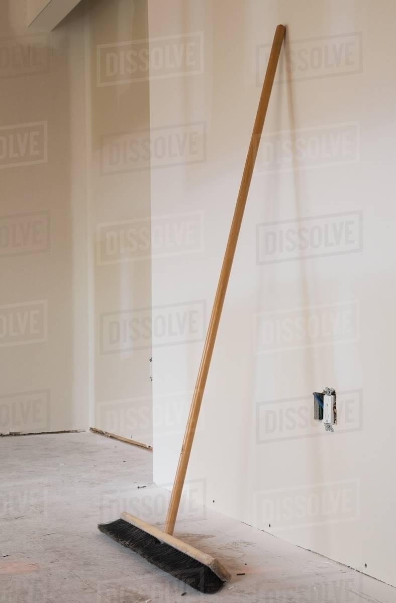 Broom leaning against a wall - Stock Photo - Dissolve