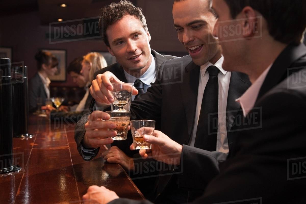 Three businessmen drinking at a bar - Royalty-free Stock Photo | Dissolve