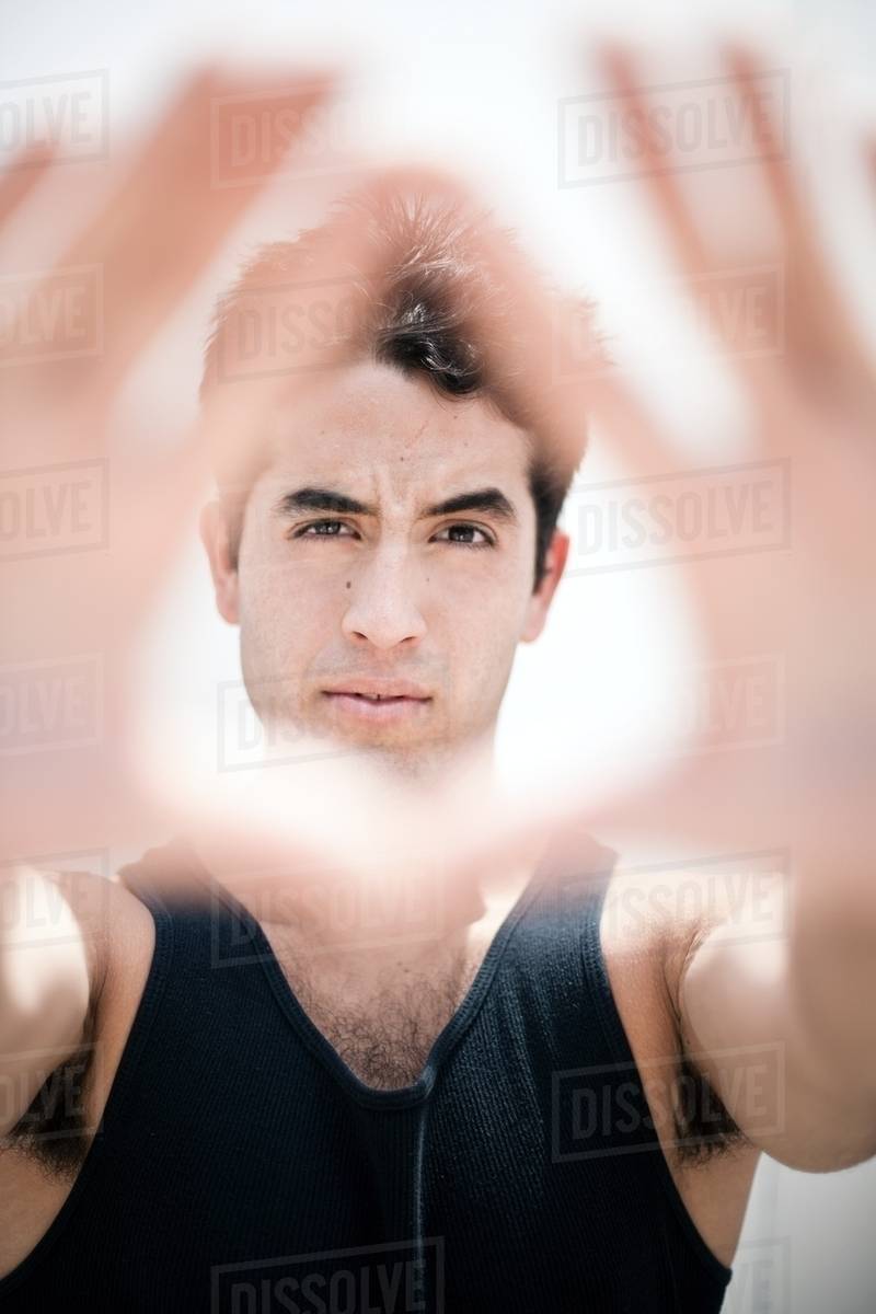 Young man holding his hands out towards camera - Stock Photo - Dissolve