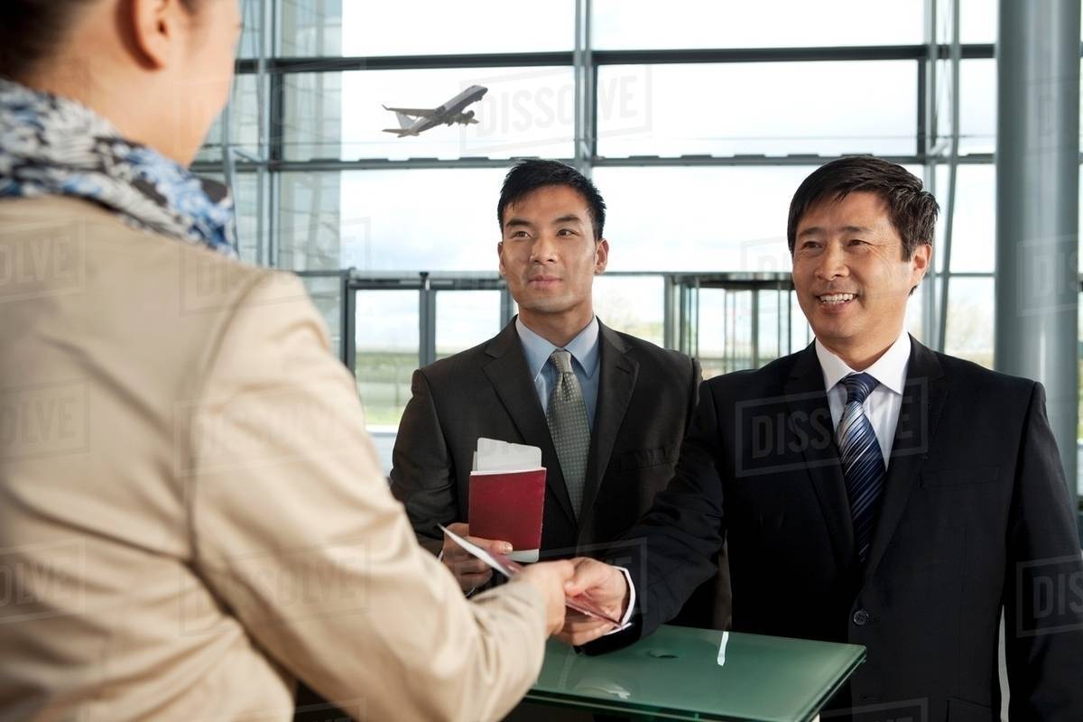 Businessmen checking in at airport - Royalty-free Stock Photo | Dissolve