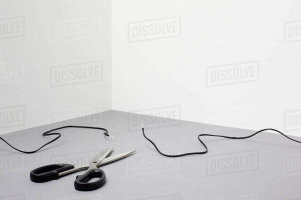 Cut telephone cable and scissors - Stock Photo - Dissolve