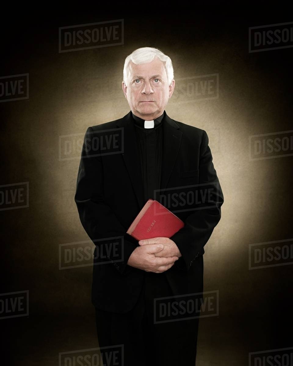 Portrait of a priest holding a bible - Royalty-free Stock Photo | Dissolve