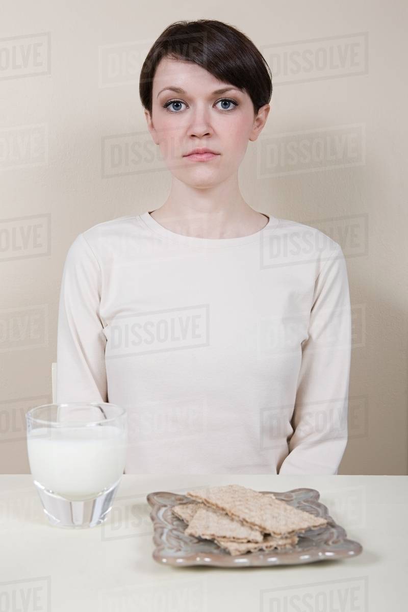 Young woman eating savoury crackers - Royalty-free Stock Photo | Dissolve