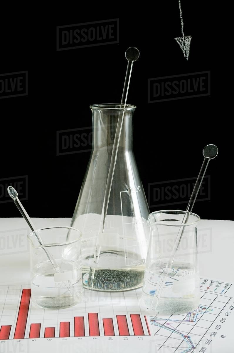 Flask and beakers on graphs - Stock Photo - Dissolve