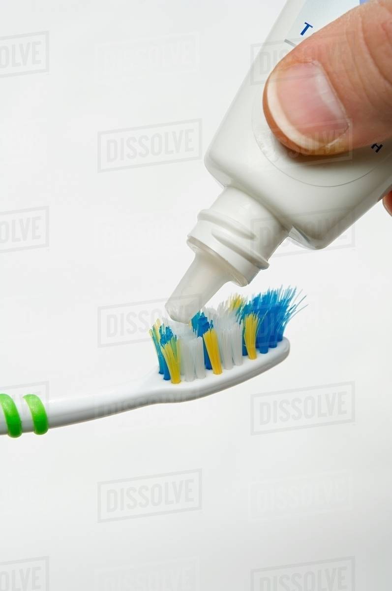 Putting toothpaste on toothbrush - Royalty-free Stock Photo | Dissolve