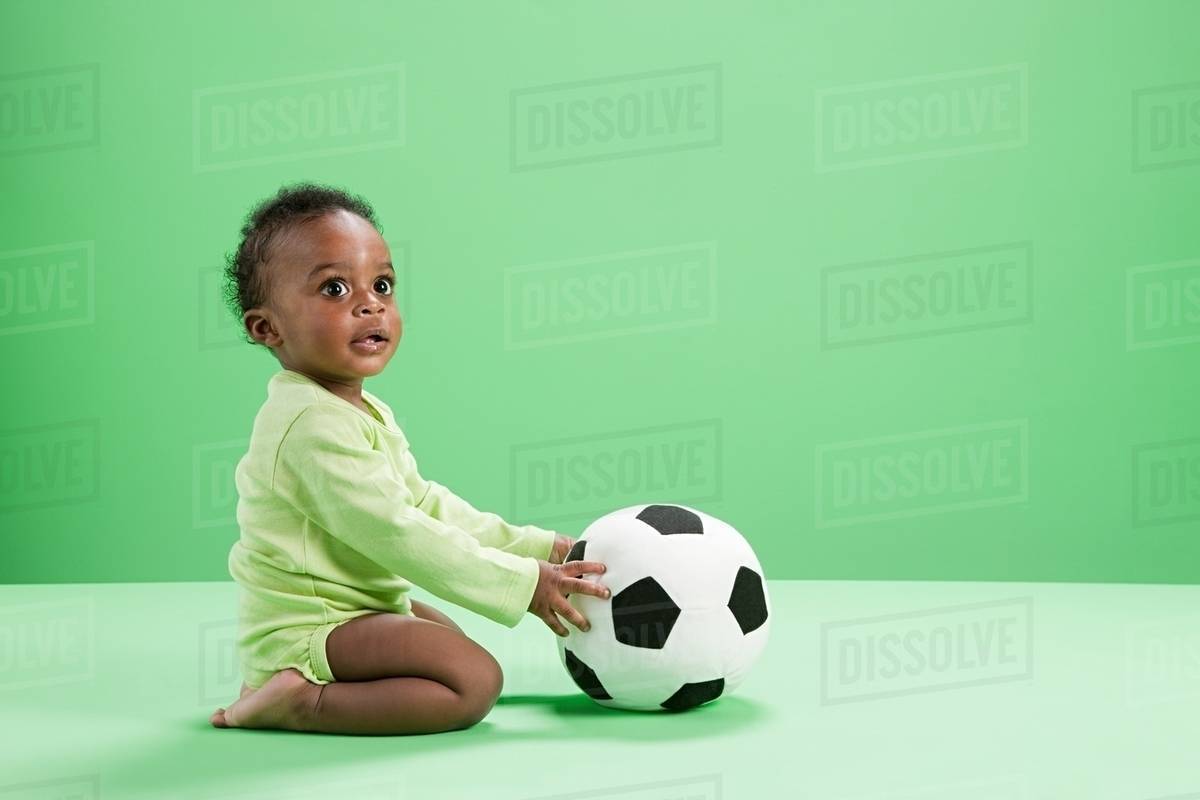 Baby boy playing with football - Stock Photo - Dissolve