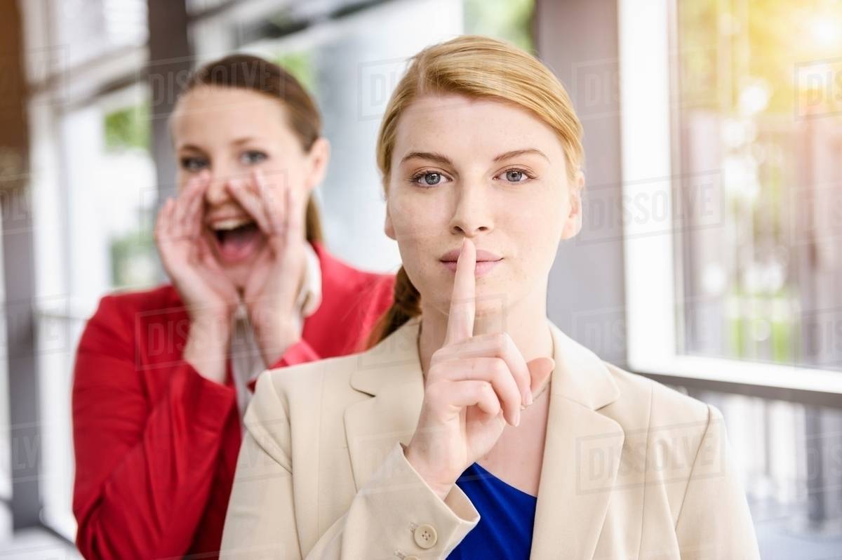 Businesswomen hiding and letting out secret - Stock Photo - Dissolve