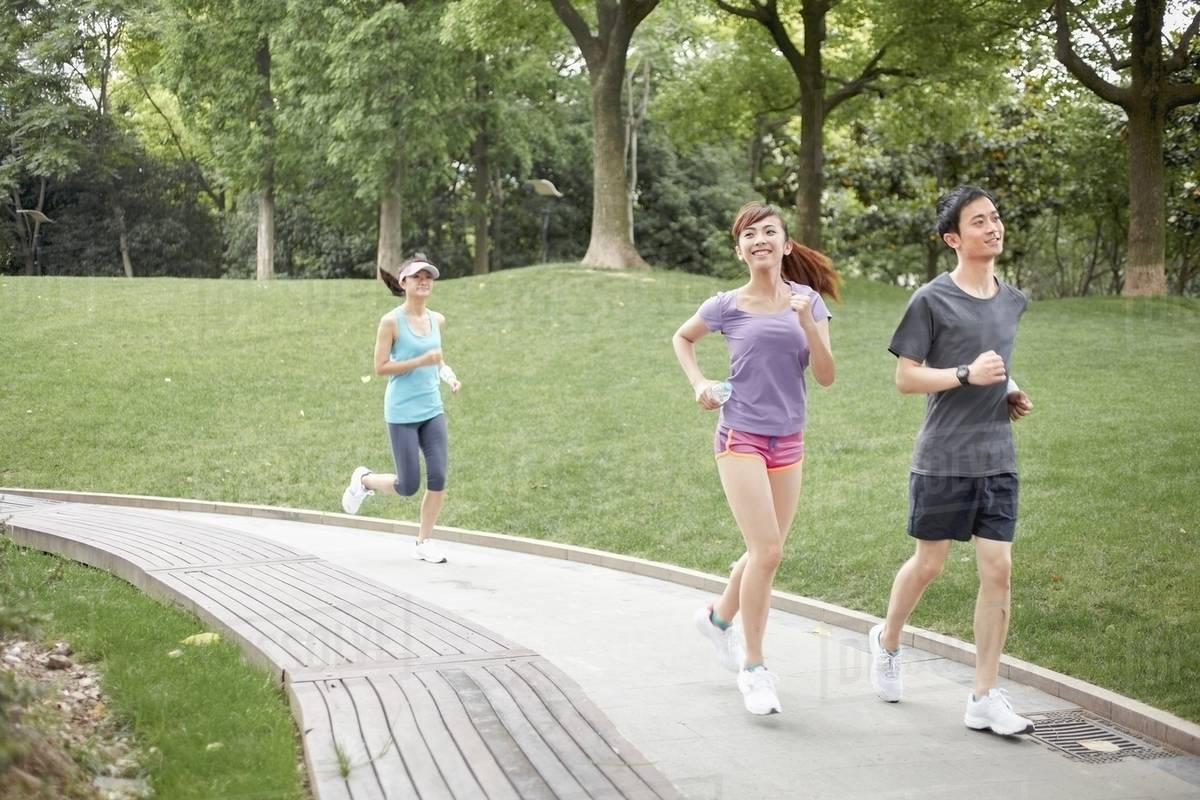 Three runners on path in park - Royalty-free Stock Photo | Dissolve