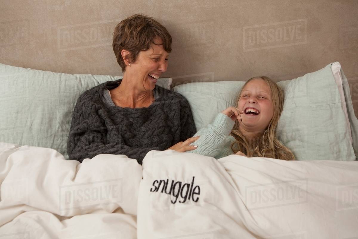 Mother and daughter laughing in bed - Royalty-free Stock Photo | Dissolve