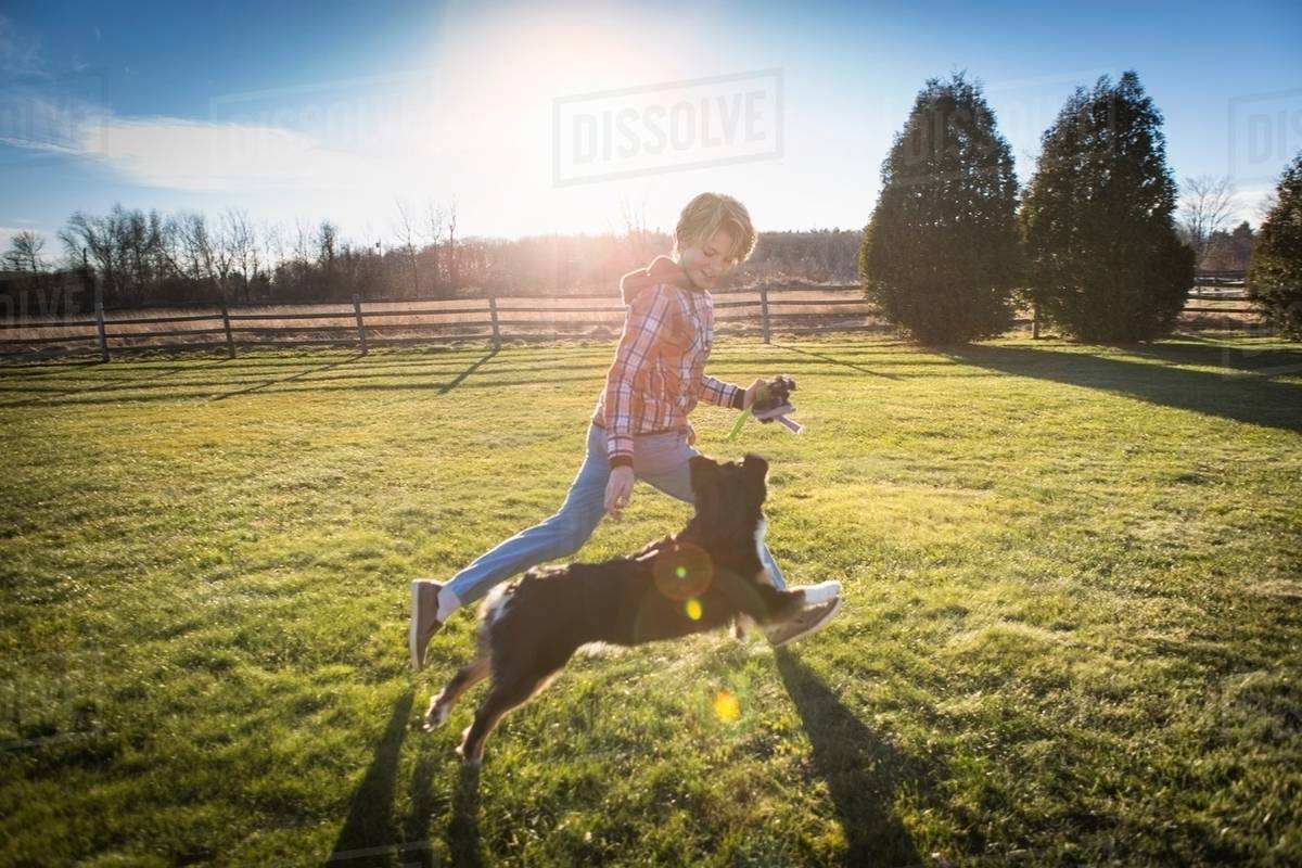 Boy running with dog - Royalty-free Stock Photo | Dissolve