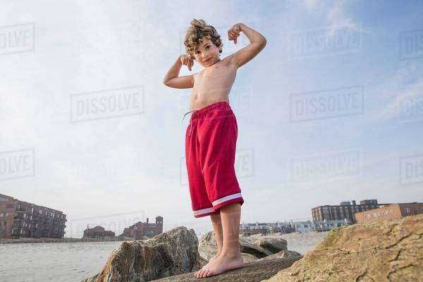 Boy at the coast showing off his arm muscles, Long Beach, New York ...