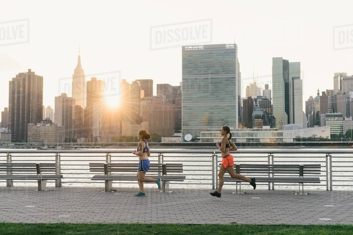 Two friends exercising together, running outdoors by river - Royalty ...