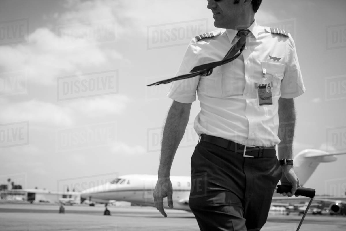 Black and white image of male private jet pilot arriving at airport ...