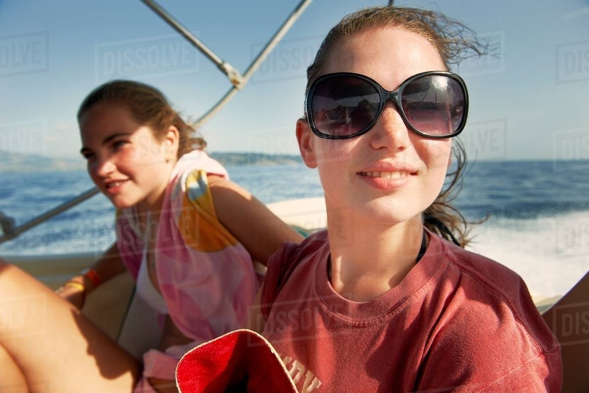 Two teenage girls on boat at sea - Stock Photo - Dissolve