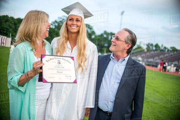 Young female graduate with parents at graduation ceremony - Stock Photo ...