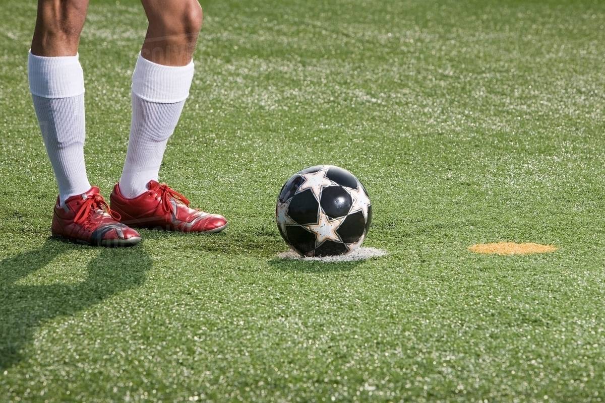 Legs of a footballer and football - Royalty-free Stock Photo | Dissolve
