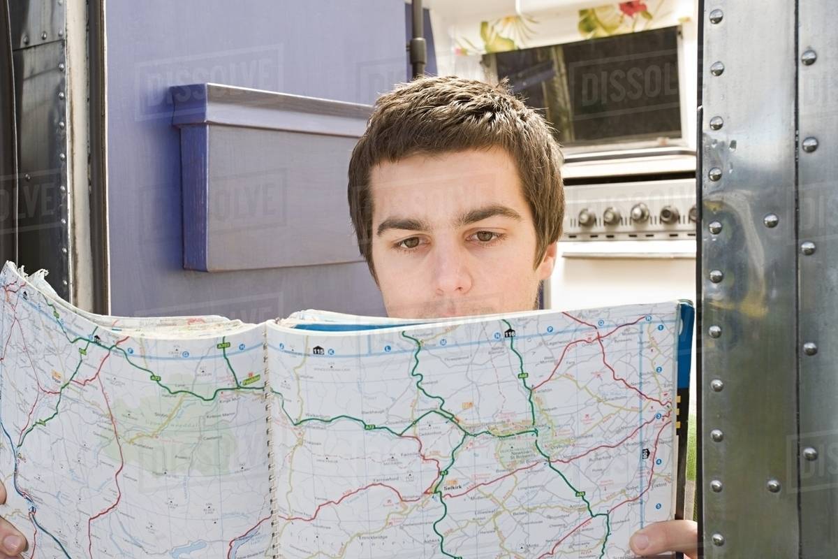 A teenage boy looking at a map - Stock Photo - Dissolve