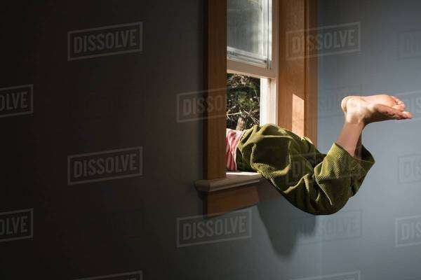 Boy climbing out of window - Stock Photo - Dissolve
