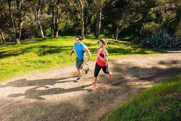 Two people jogging on forest path - Stock Photo - Dissolve