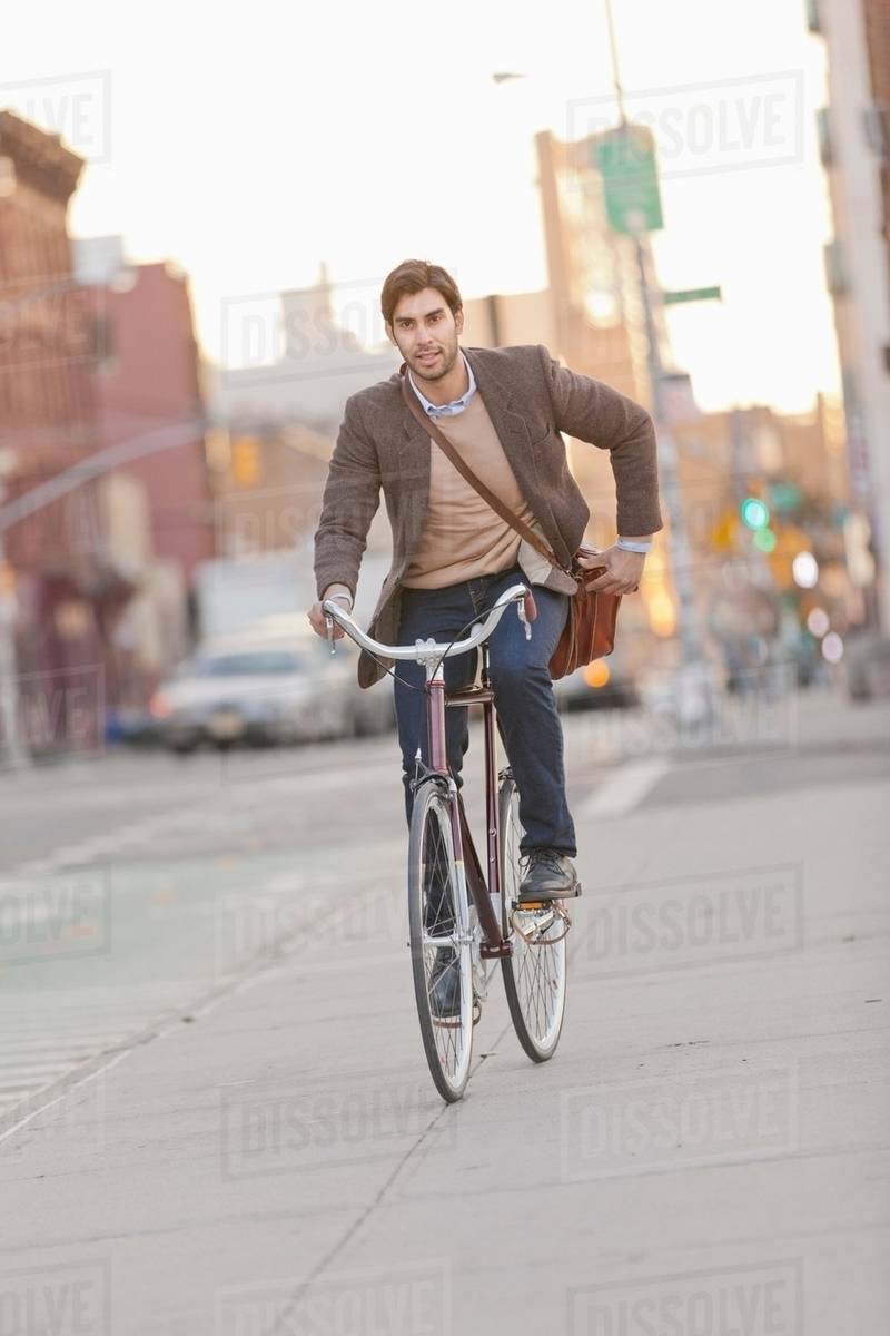 Man riding bicycle on city street - Stock Photo - Dissolve