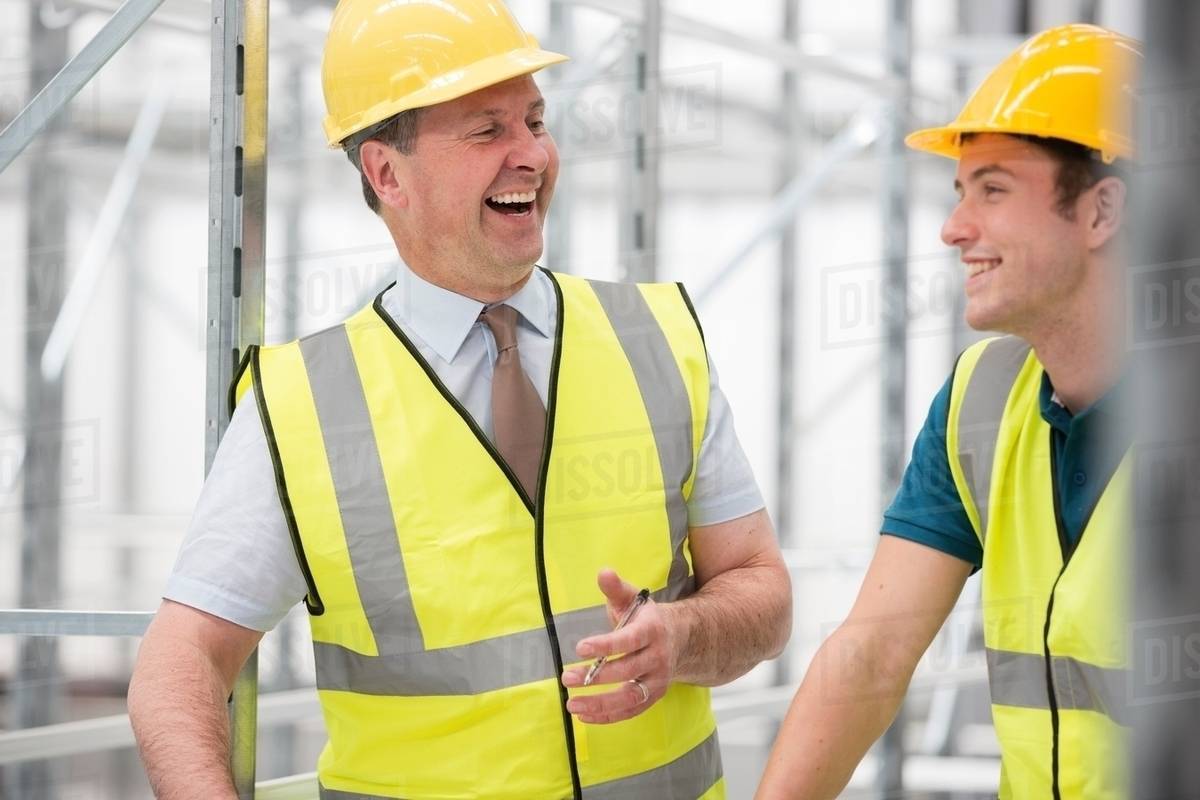 Two men laughing in warehouse - Royalty-free Stock Photo | Dissolve