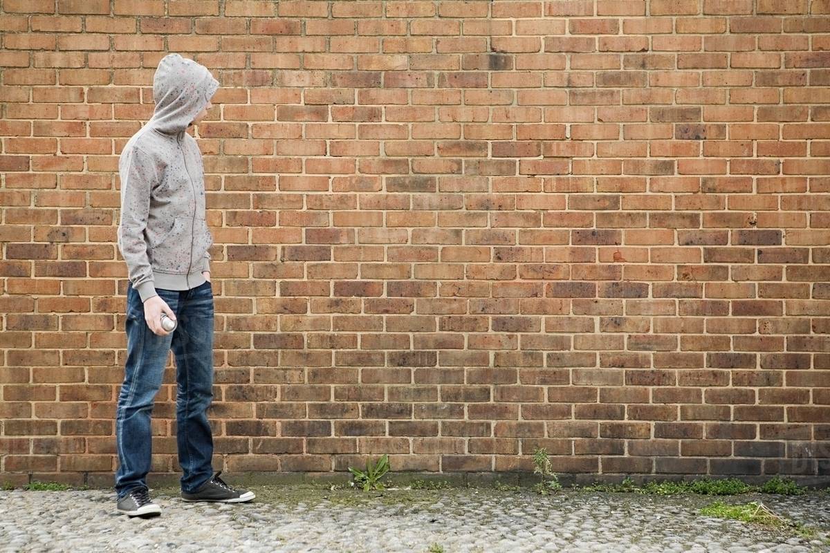 Boy by wall with spray can - Royalty-free Stock Photo | Dissolve