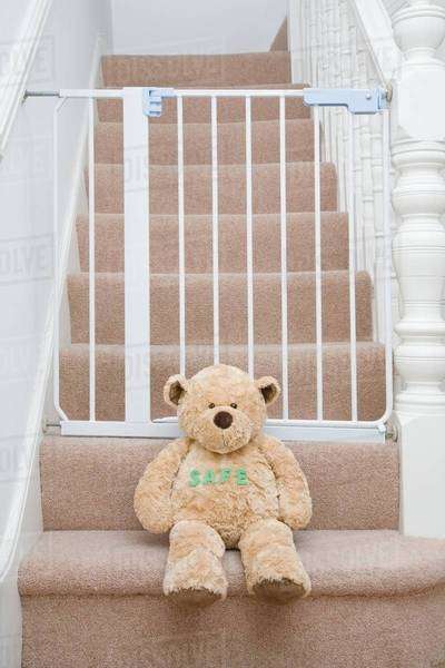 Teddy bear and stair gate - Stock Photo - Dissolve