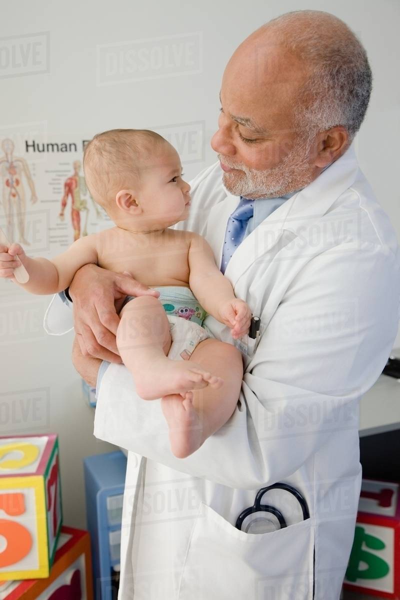 A doctor holding a baby - Royalty-free Stock Photo | Dissolve
