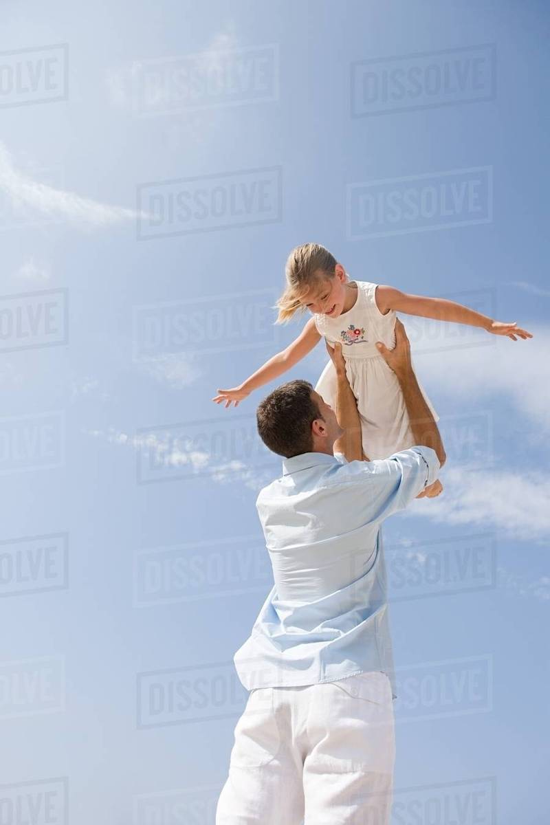 Father lifting daughter - Stock Photo - Dissolve