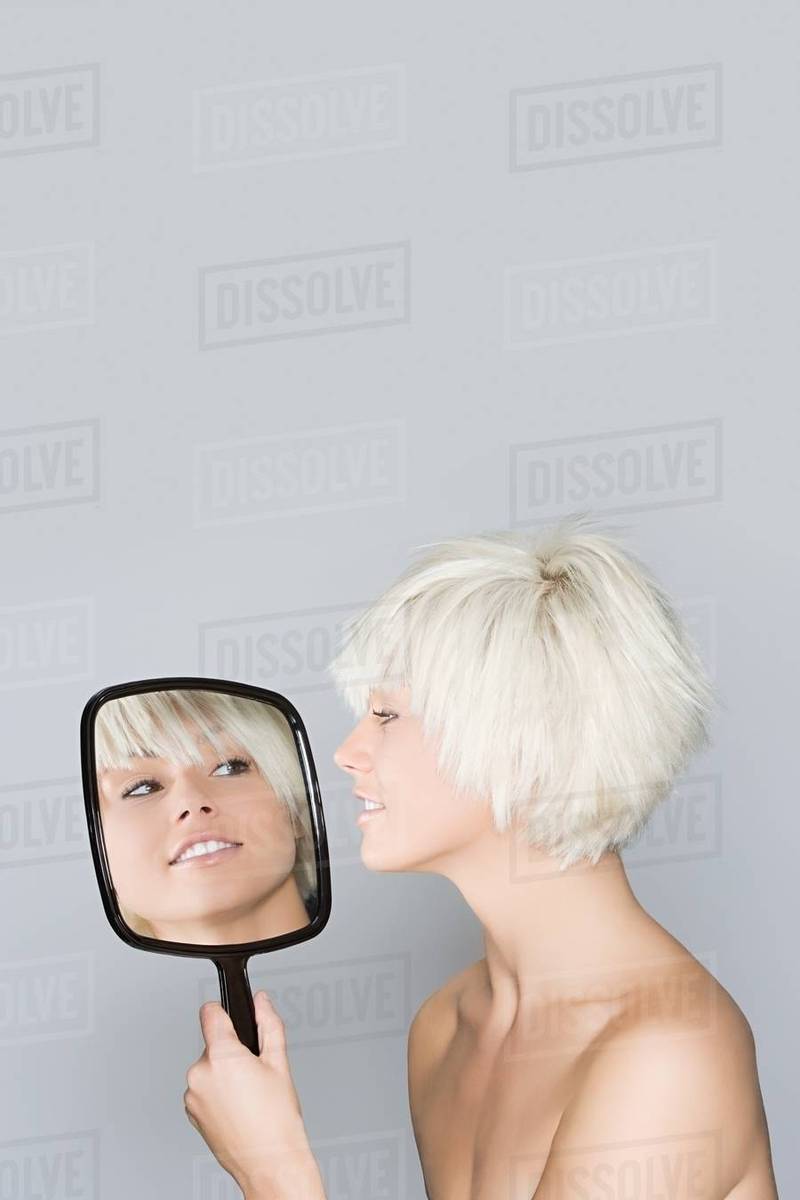 A woman looking at her reflection - Royalty-free Stock Photo | Dissolve