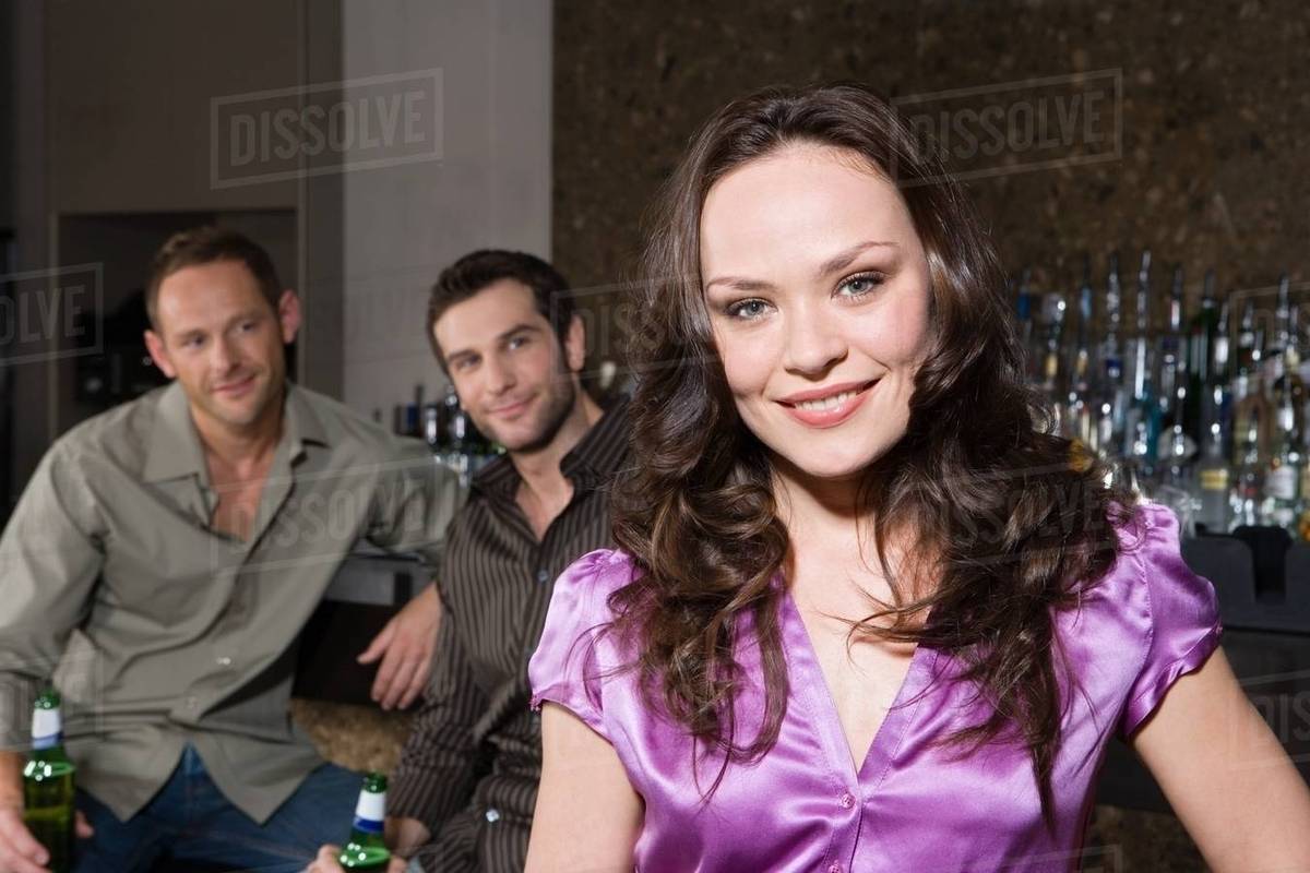 Men looking at a woman in bar - Royalty-free Stock Photo | Dissolve