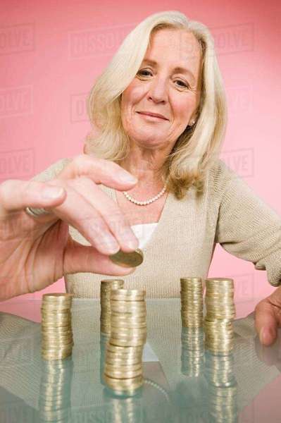 Woman stacking coins - Royalty-free Stock Photo | Dissolve