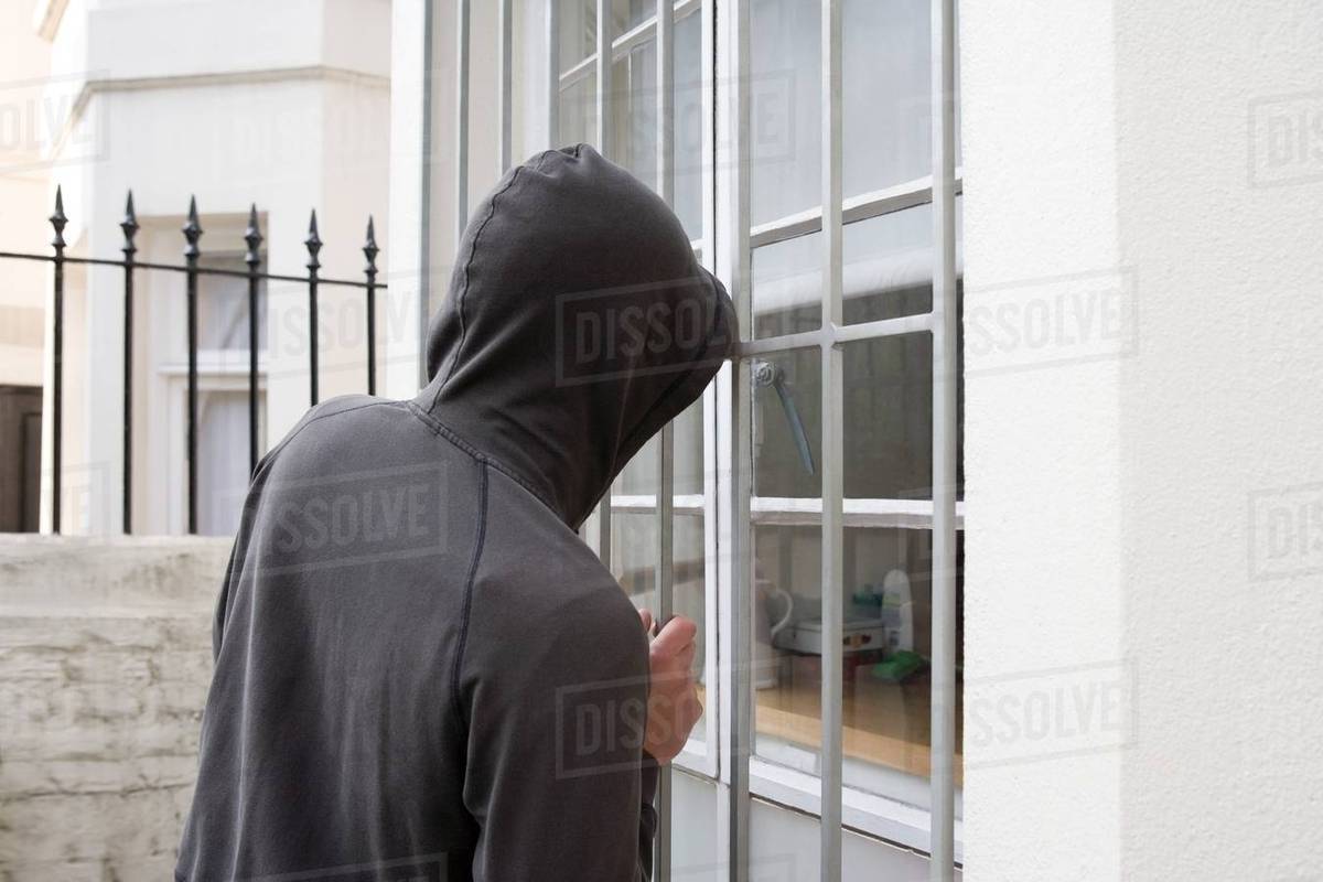 A thief looking through a window - Royalty-free Stock Photo | Dissolve