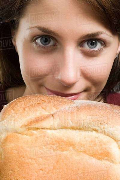 Portrait of a woman smelling bread - Stock Photo - Dissolve