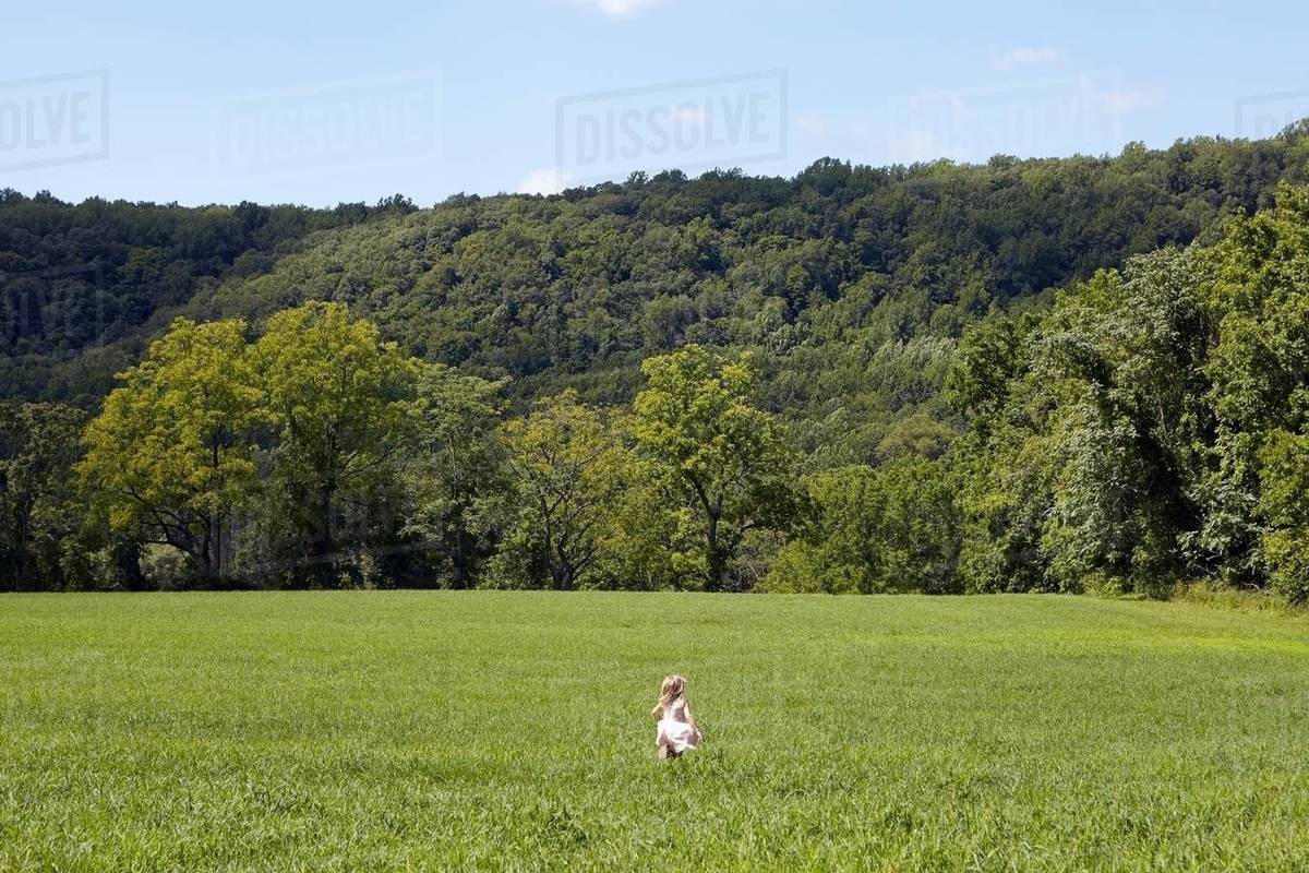 Girl running in field - Royalty-free Stock Photo | Dissolve