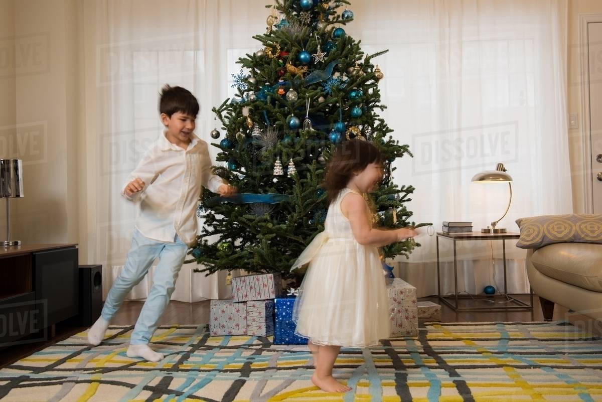 Children playing around Christmas tree - Royalty-free Stock Photo ...