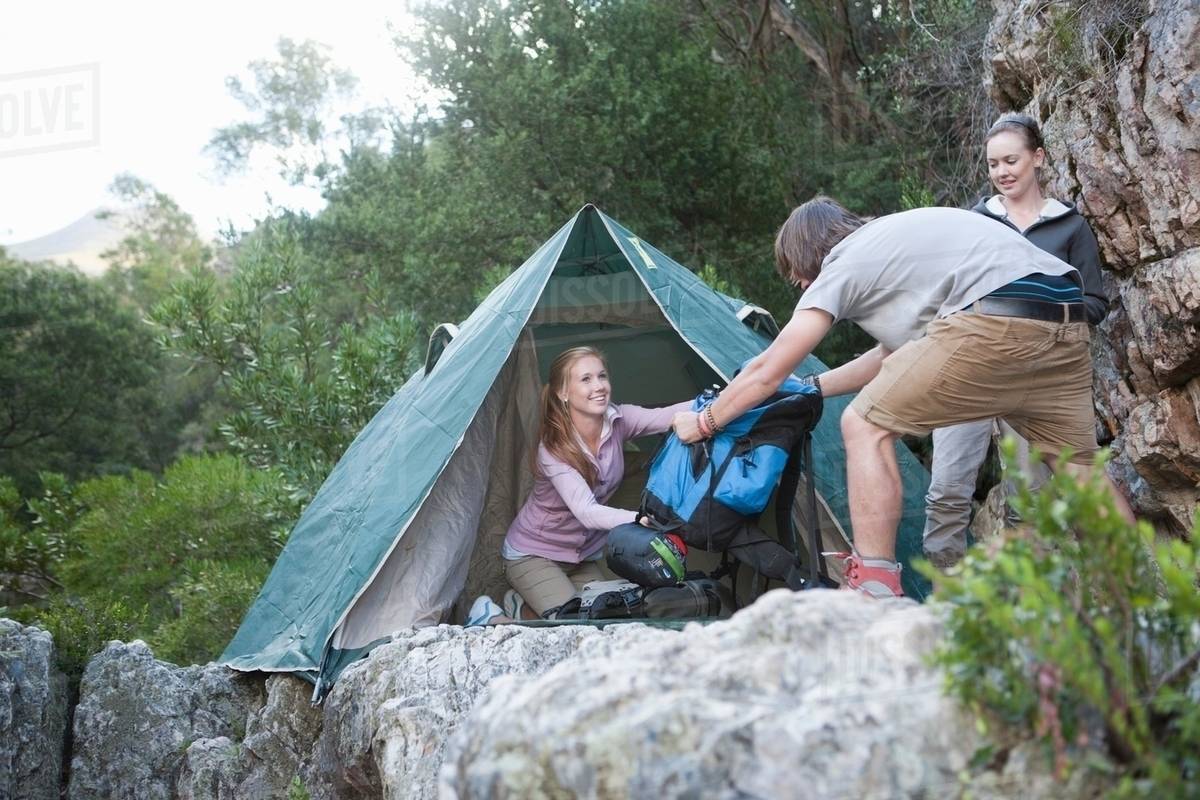 Young people camping on rocks - Stock Photo - Dissolve
