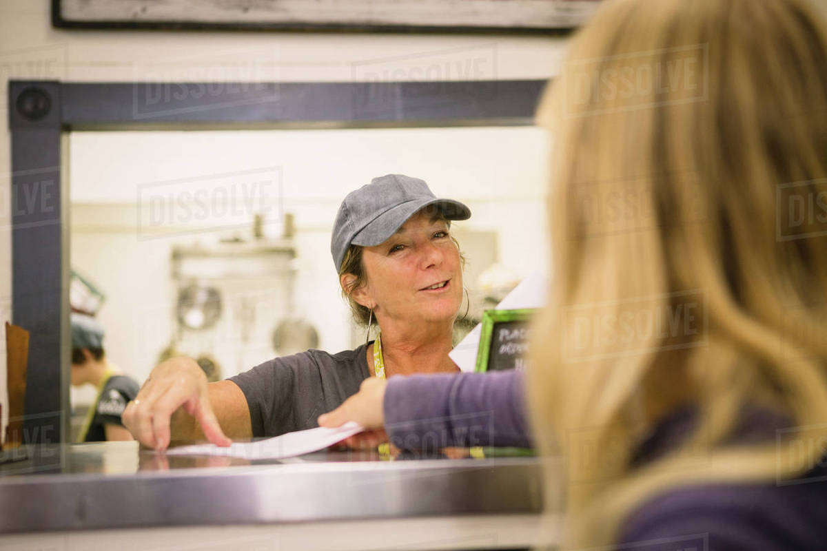 Employee in general store serving customer at counter - Stock Photo ...