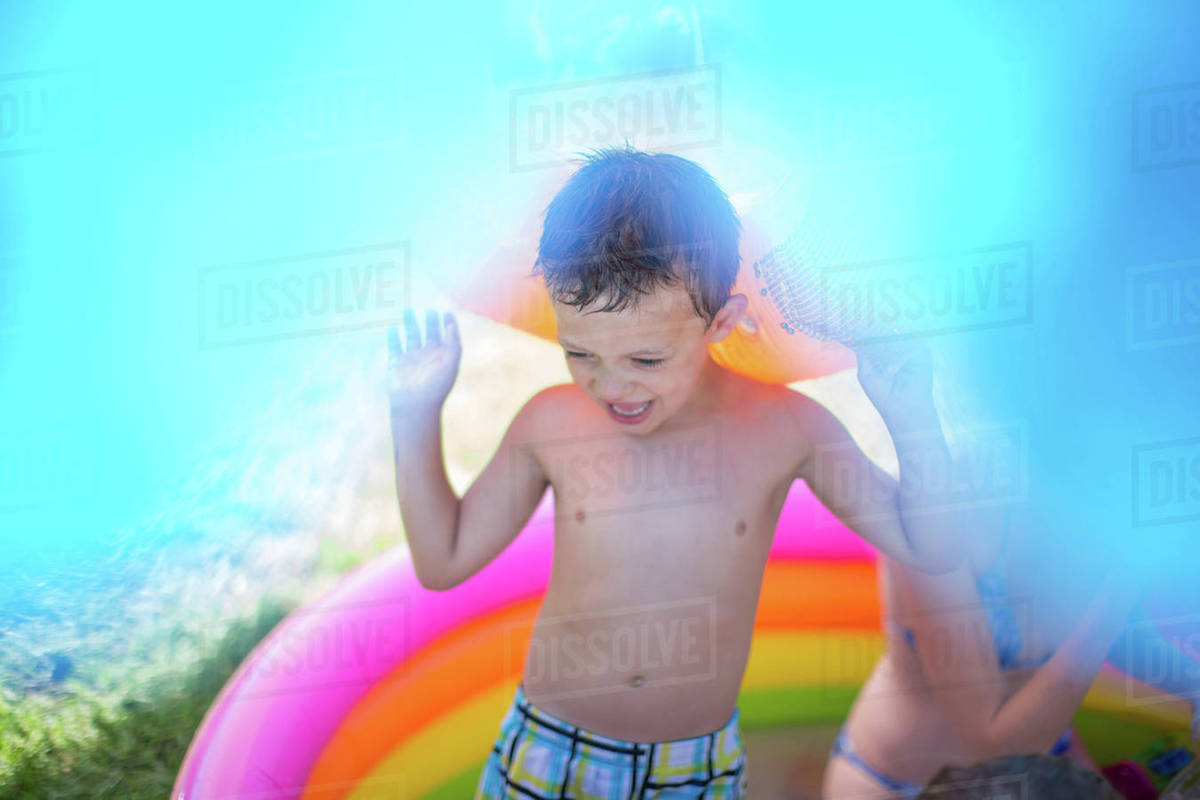 Boy playing in inflatable pool - Royalty-free Stock Photo | Dissolve