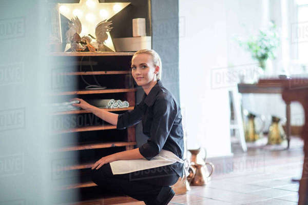 Waitress tidying shelves in restaurant - Royalty-free Stock Photo ...