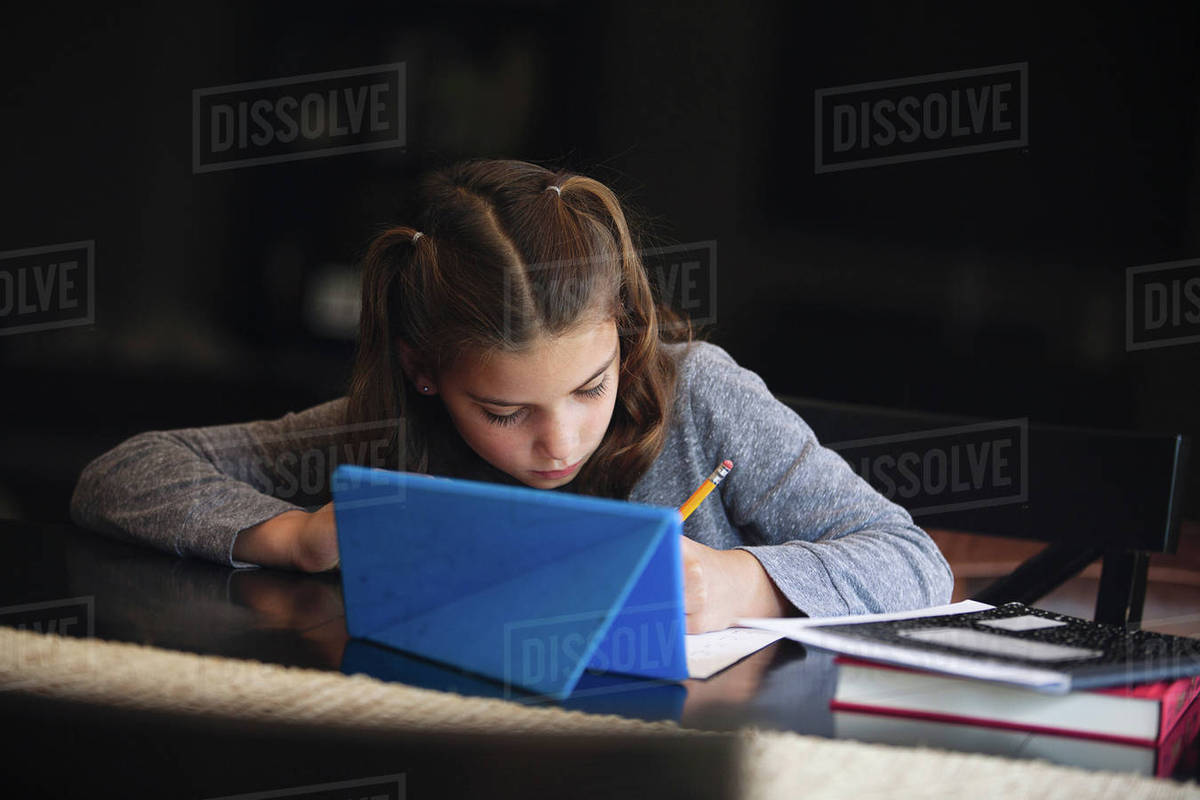 Girl at desk writing - Royalty-free Stock Photo | Dissolve