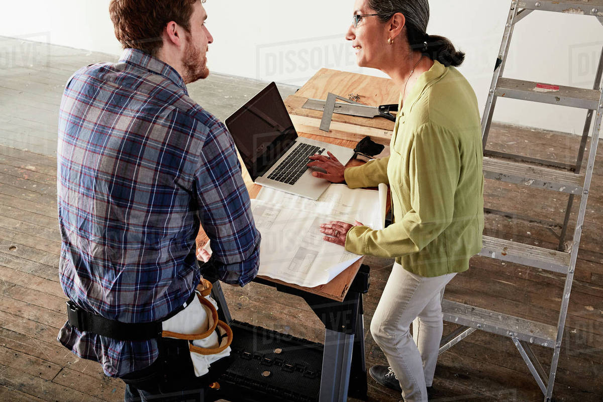 Carpenter and client with blueprints using laptop - Royalty-free Stock ...