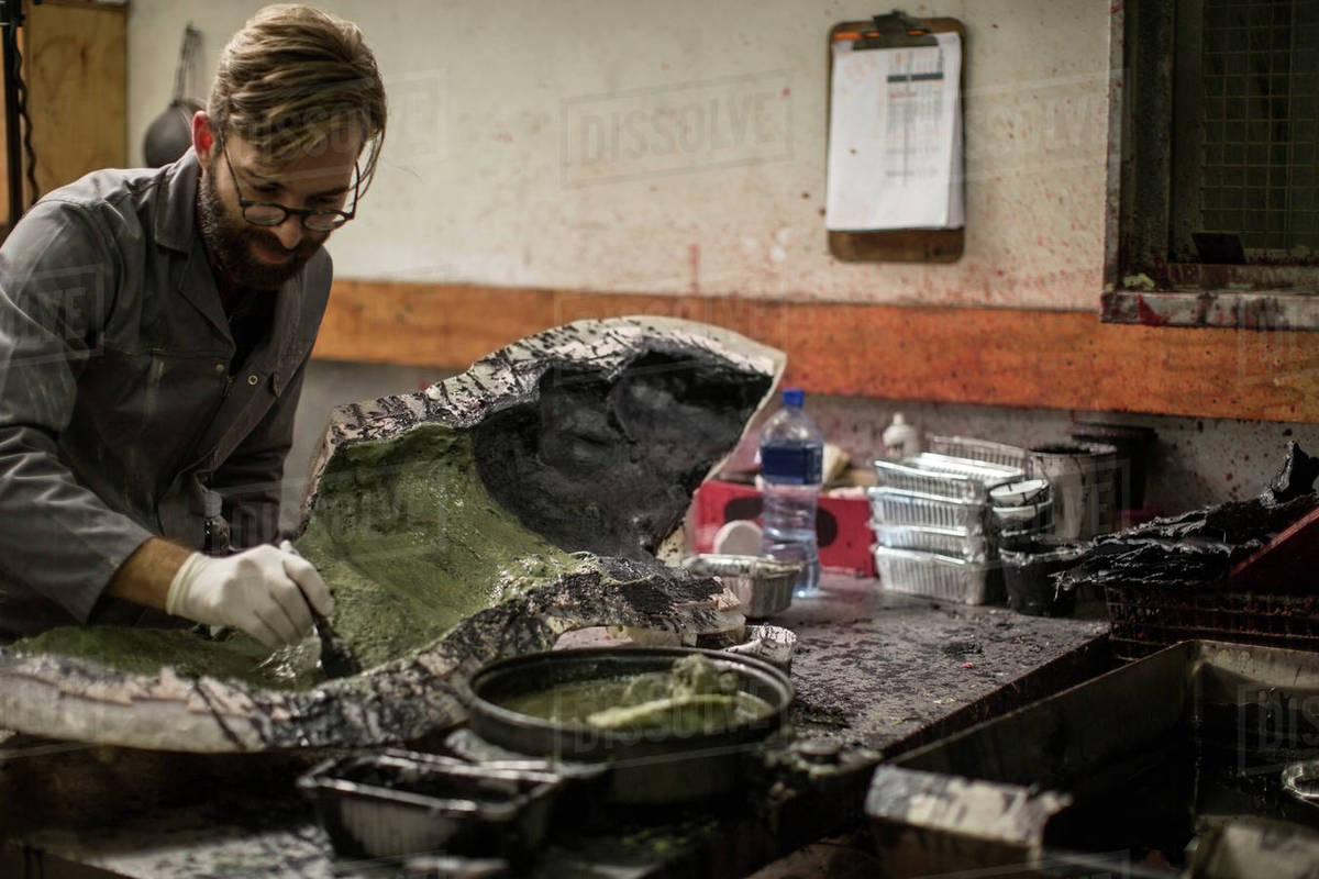Sculptor in artists' studio creating sculpture - Stock Photo - Dissolve