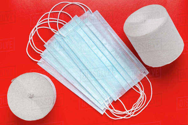 Medical surgical face masks and rolls of toilet paper on red background ...
