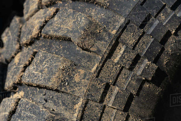 Old used rubber extreme terrain tire with worn wear-resistant tread ...